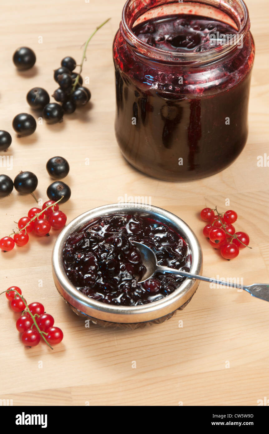 Black and red currant jam and berries on a wooden table Stock Photo - Alamy
