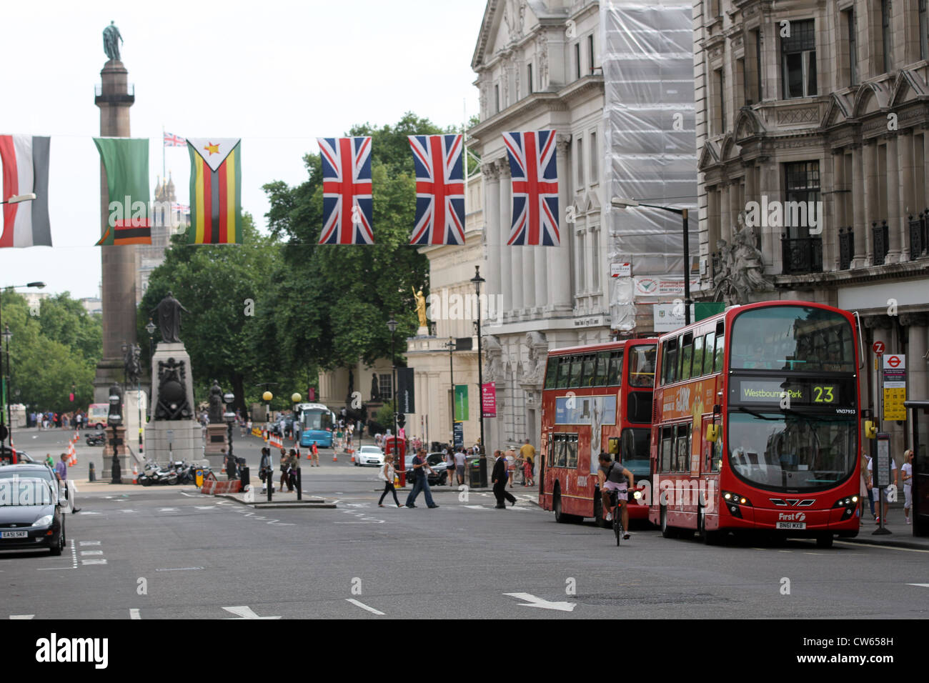 London Red double decker buses and taxis in Waterloo Place London, with ...