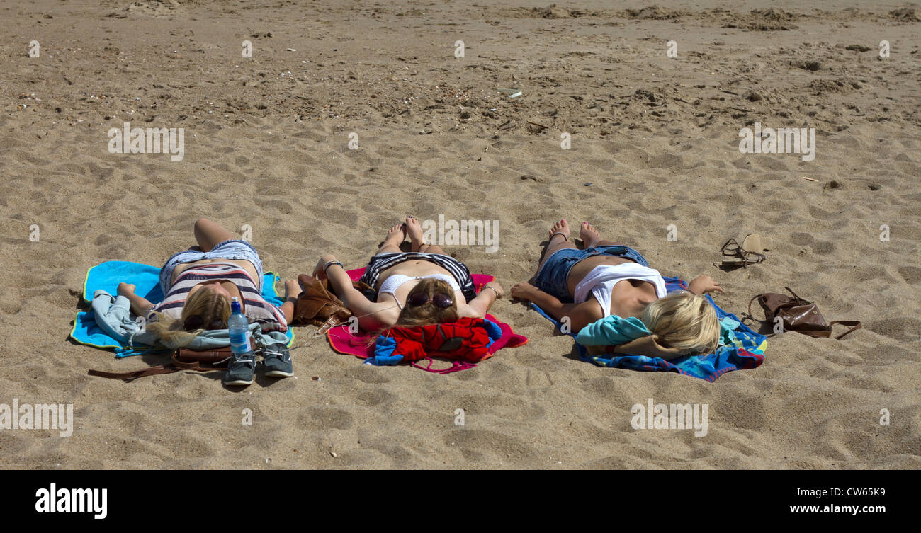 Three ladies sunbathing Stock Photo - Alamy