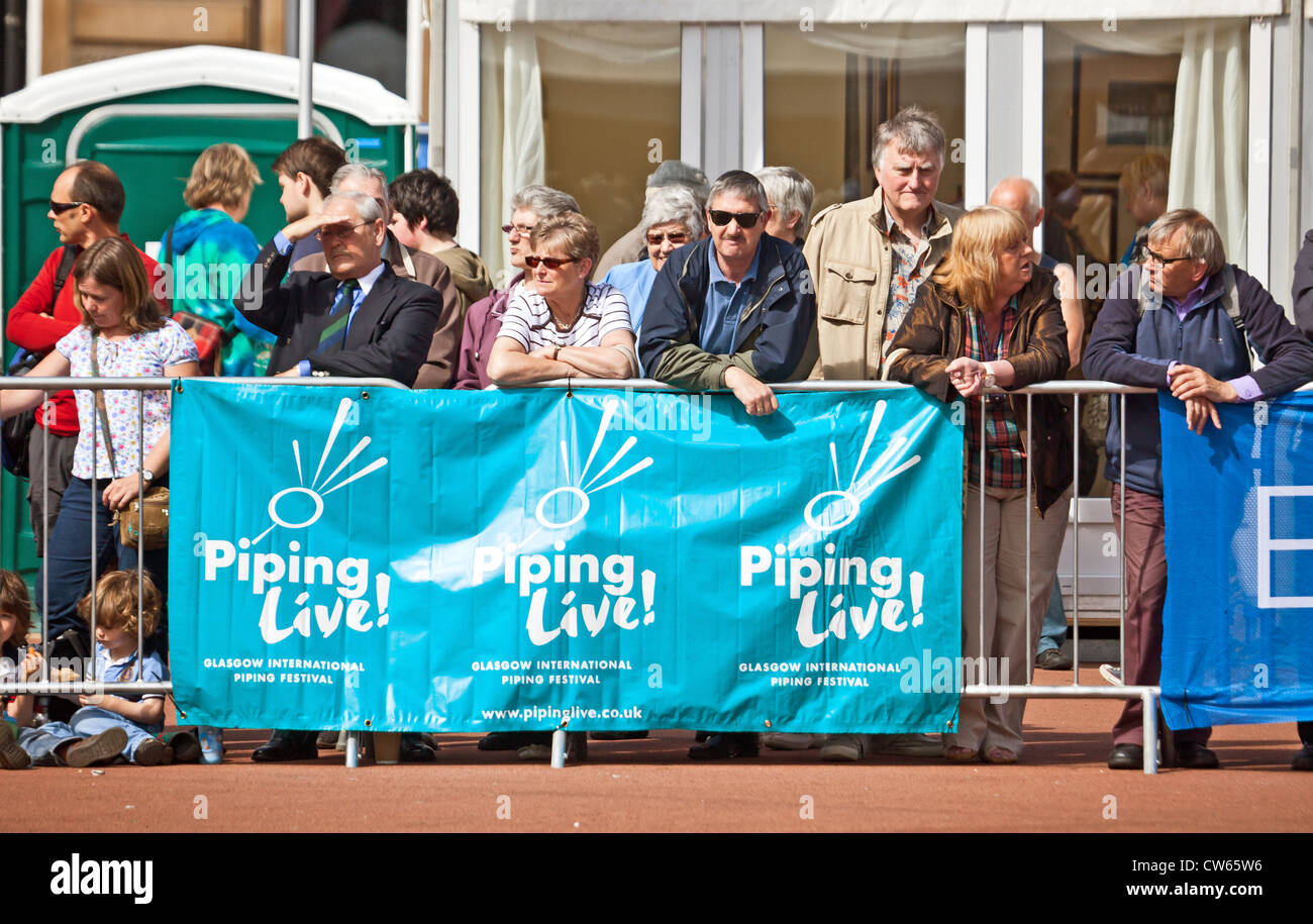 Audience for a performance in George Square, behind a banner for Piping ...