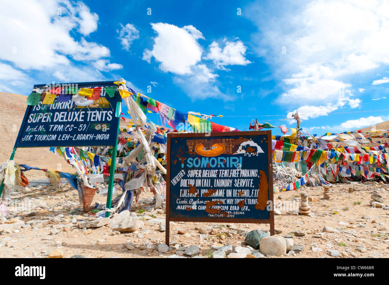 Two signs festooned with prayer flags advertising Tsomoriri Super ...