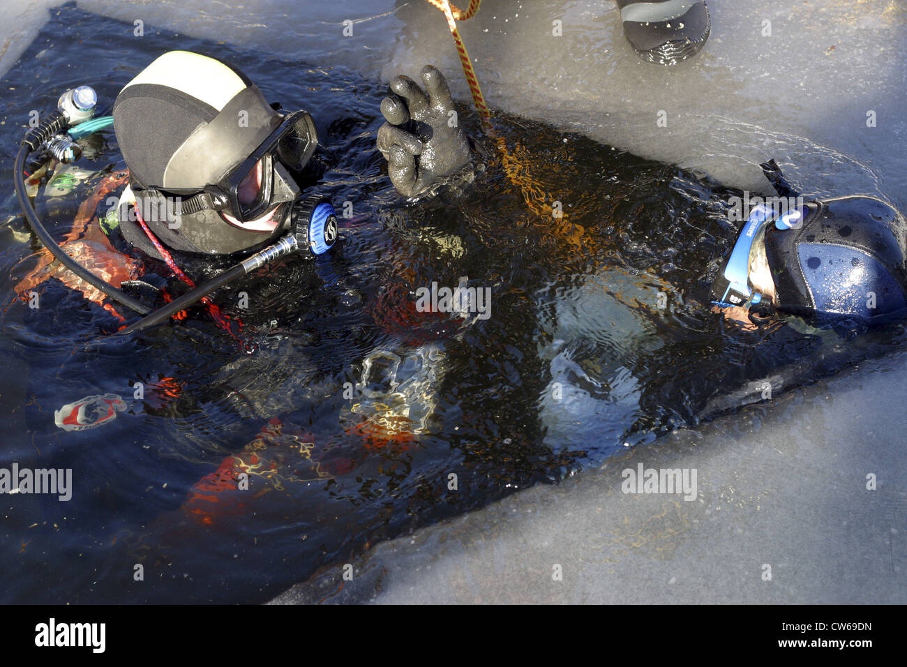 ice diver preparing to dive into frozen lake, Germany, North Rhine ...