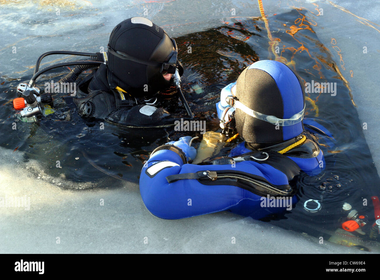 ice diver preparing to dive into frozen lake, Germany, North Rhine ...