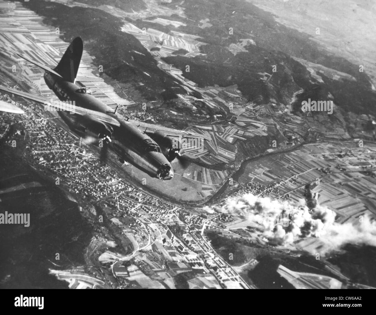 A B-26 swoops down over a blazing German ordnance depot in Rudolstadt ...