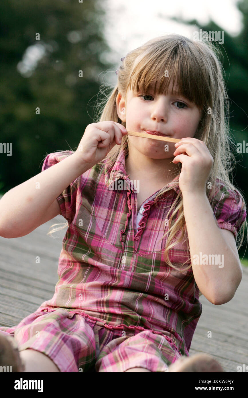 young girl eating an iced lolly Stock Photo - Alamy