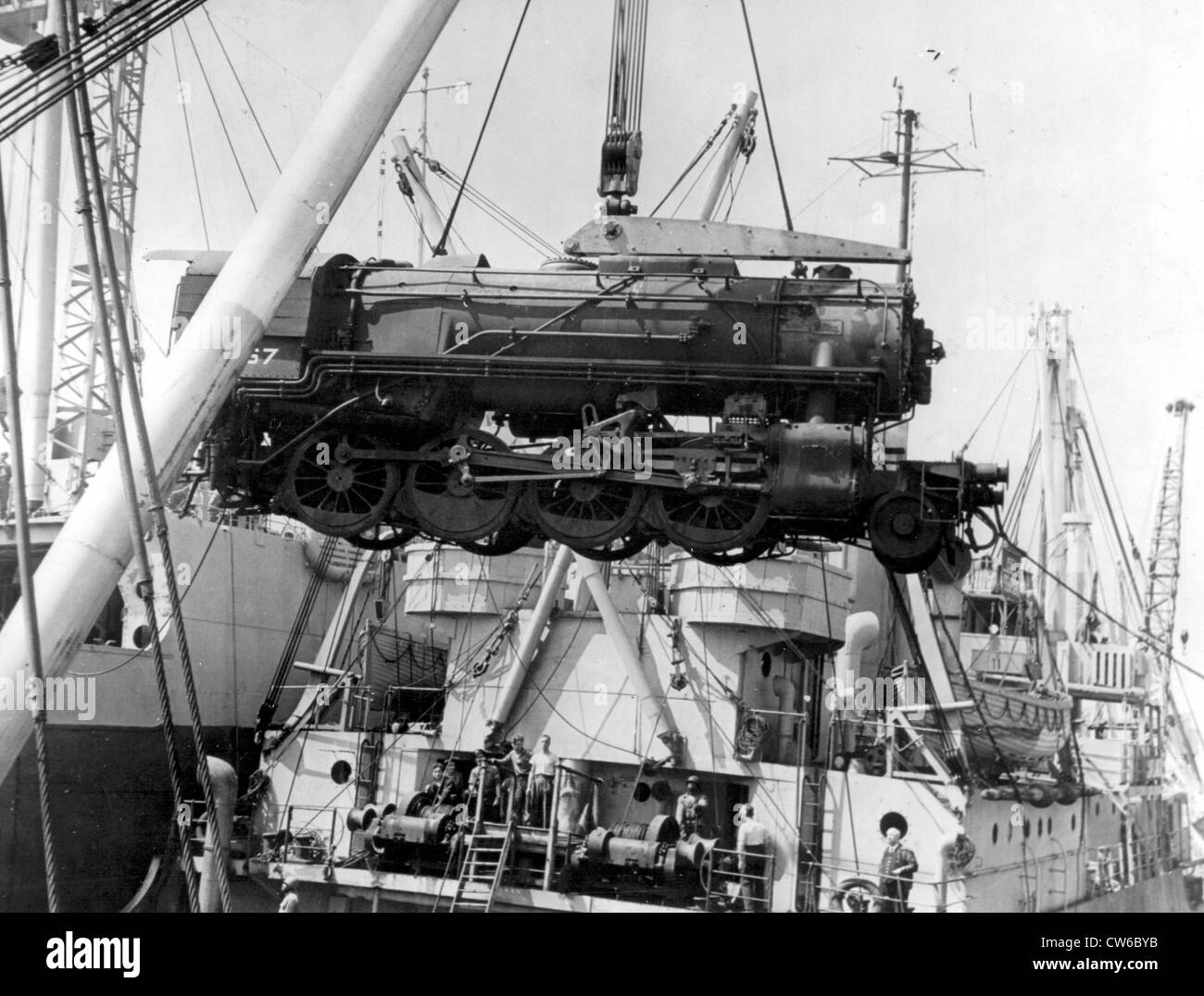 A heavy American freight engine is swung ashore at Cherbourg harbour in ...