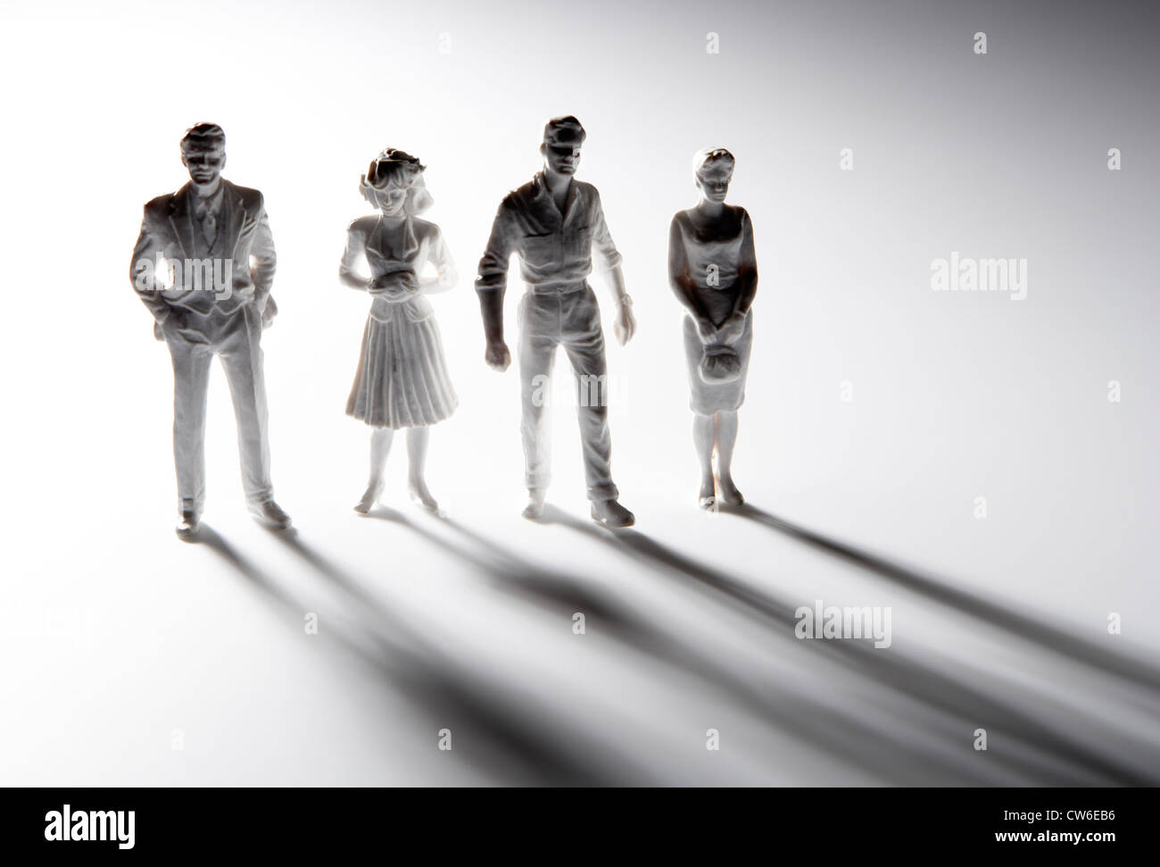 Four miniature figures with shadows against a white background Stock ...