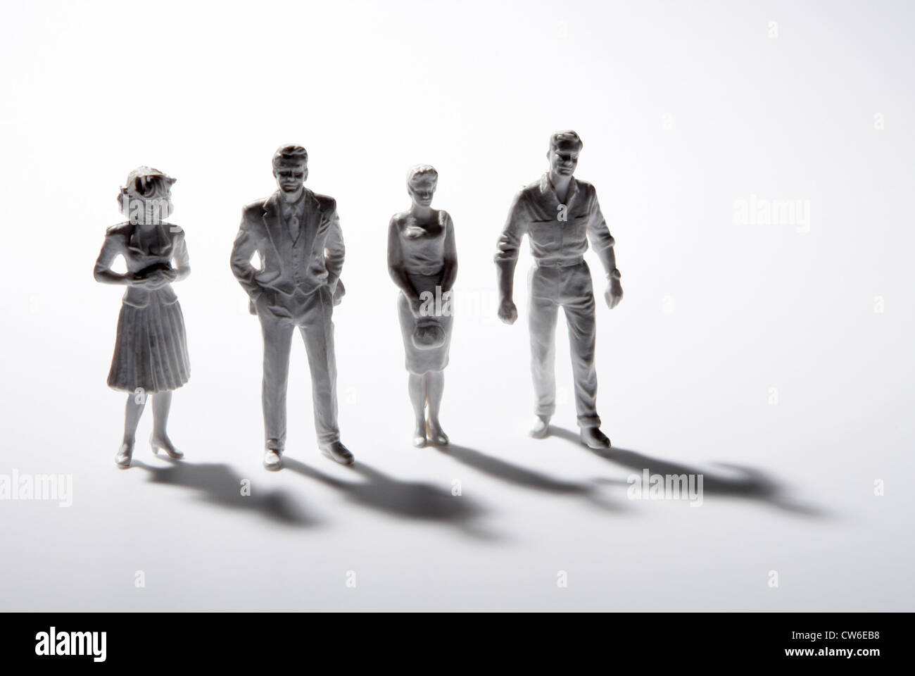 Four miniature figures with shadows against a white background Stock ...