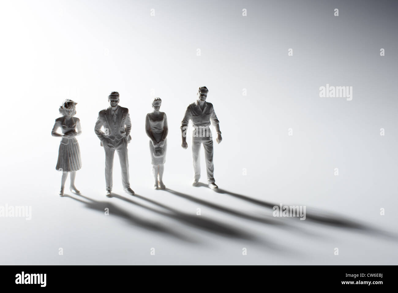 Four miniature figures with shadows against a white background Stock ...