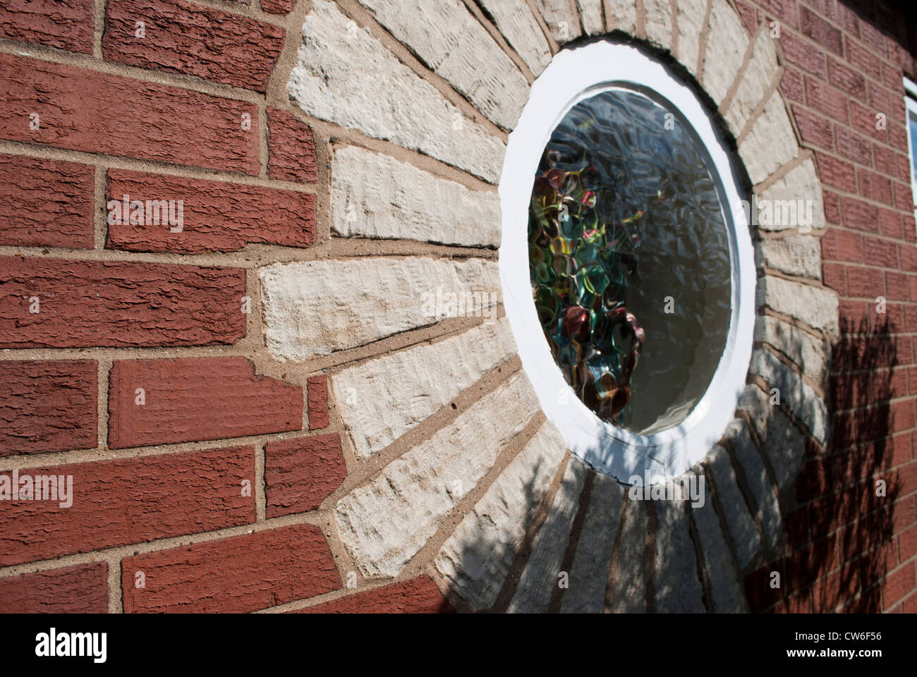 Round window with stone surround in red brick wall Stock Photo - Alamy