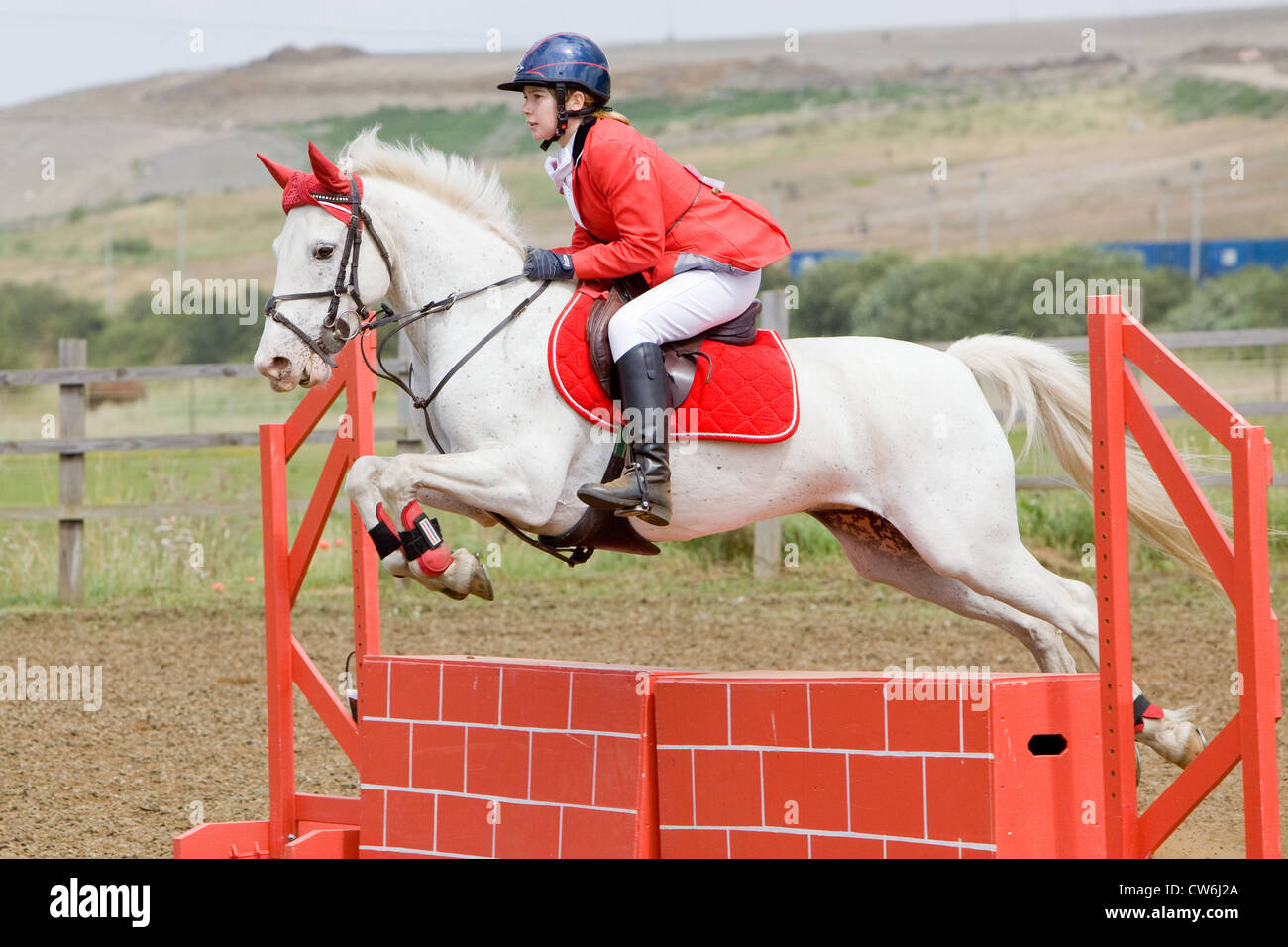A horse and rider jumping a fence during a show jumping competition ...