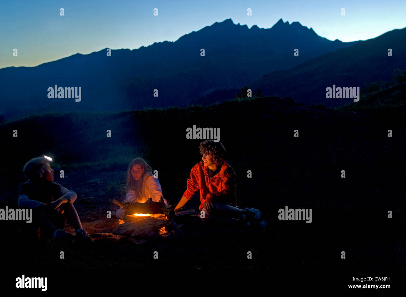 Girl sitting around campfire hi-res stock photography and images - Alamy