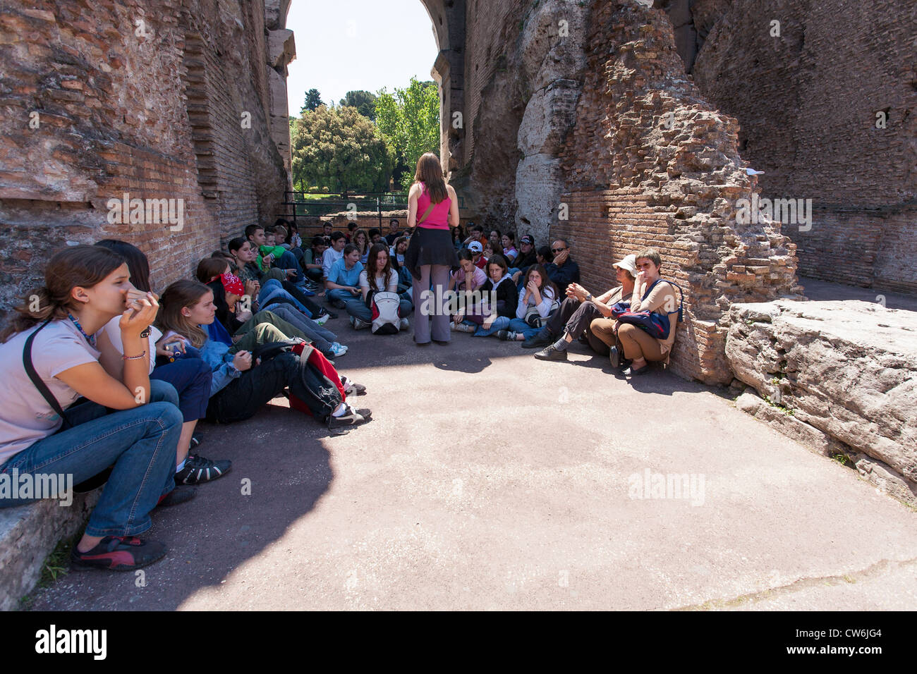 School class receiving instruction (in the shade at the colosseum rome ...