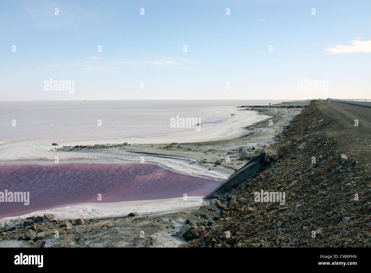 salt lake in Chott el-J rid with red water and road crossing the lake ...