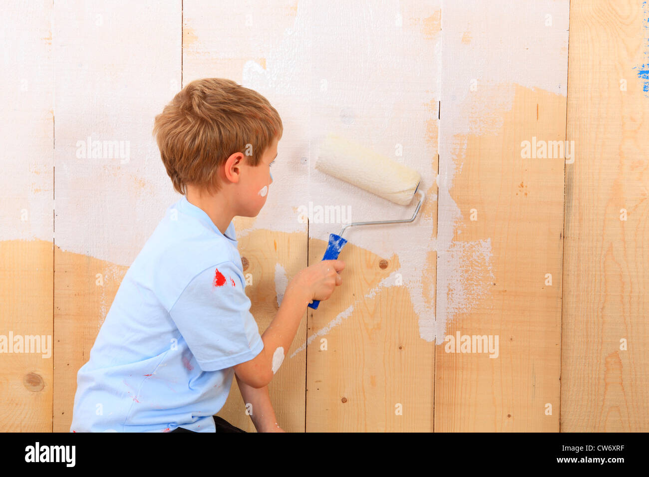 boy painting a wooden wall white using a paint roller Stock Photo - Alamy