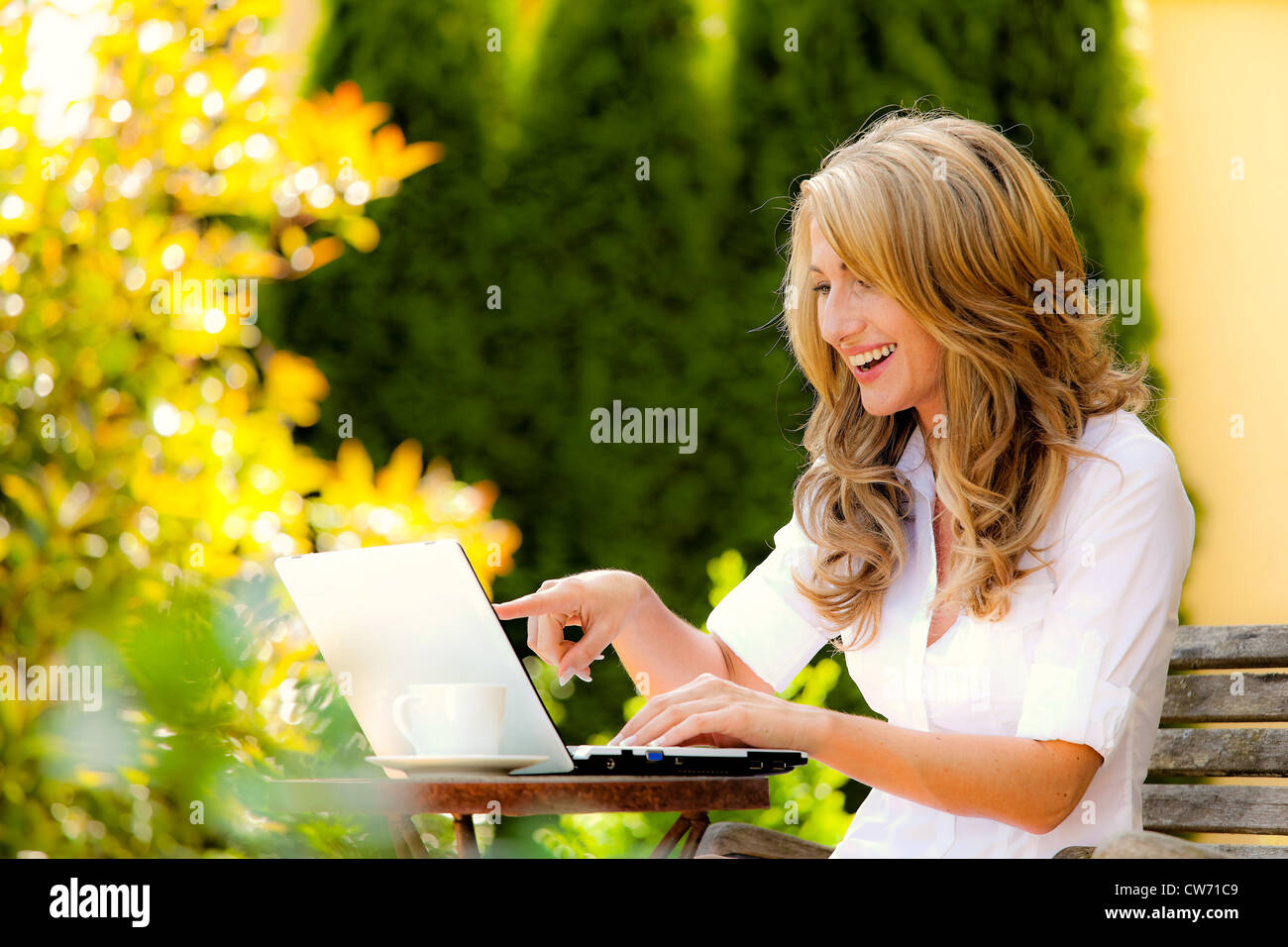 Woman with laptop in garden Stock Photo - Alamy