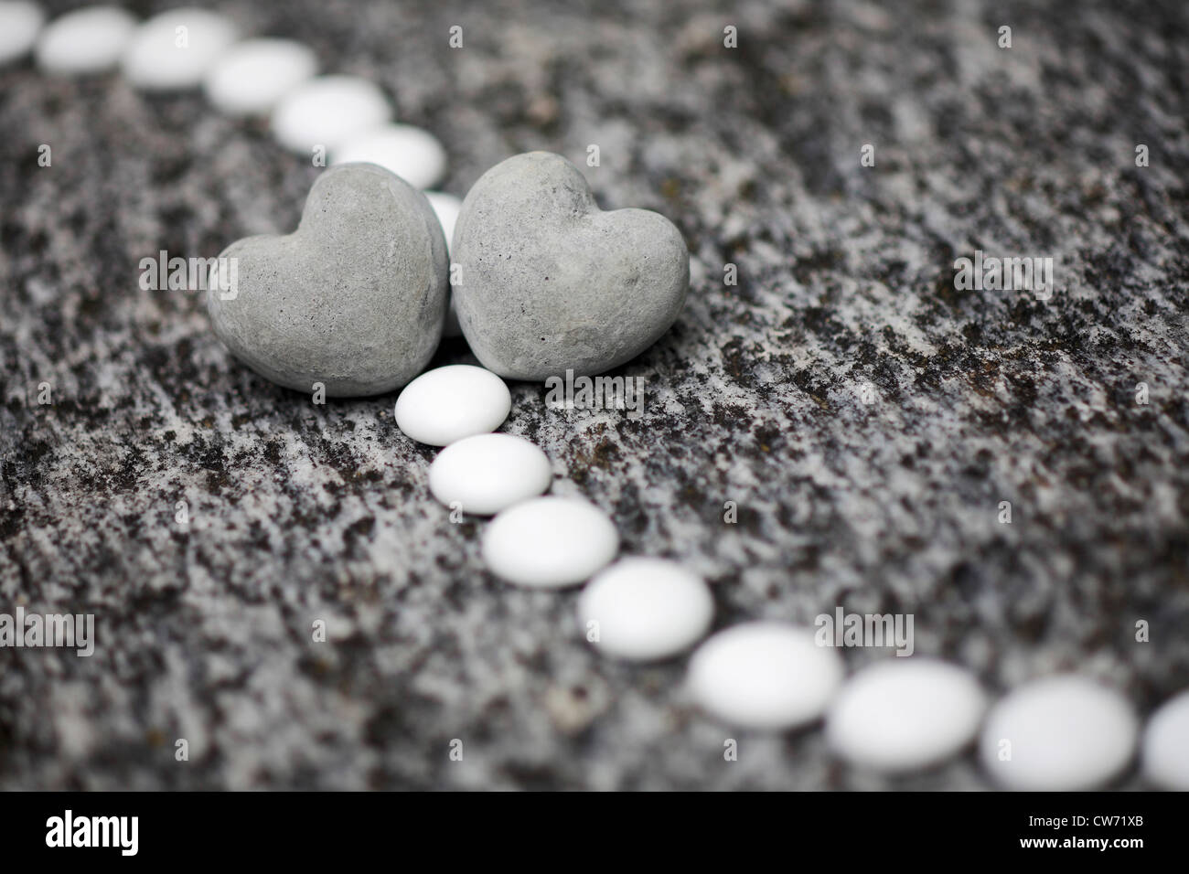 two heart-shaped stones and small stones in wiggly line, Switzerland ...