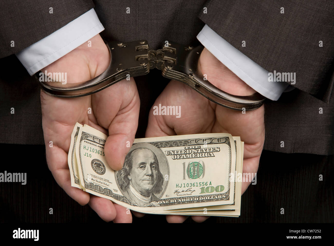 man with handcuffs holding Dollar banknotes in his hands, USA; Amerika ...