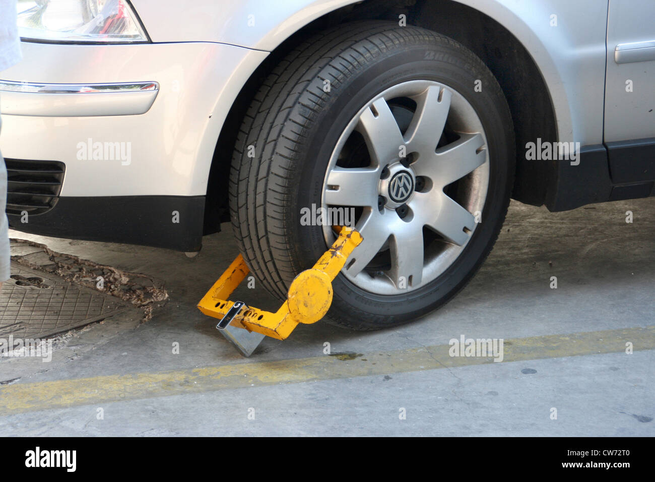 wheel of a passenger car with a wheel clamp Stock Photo - Alamy