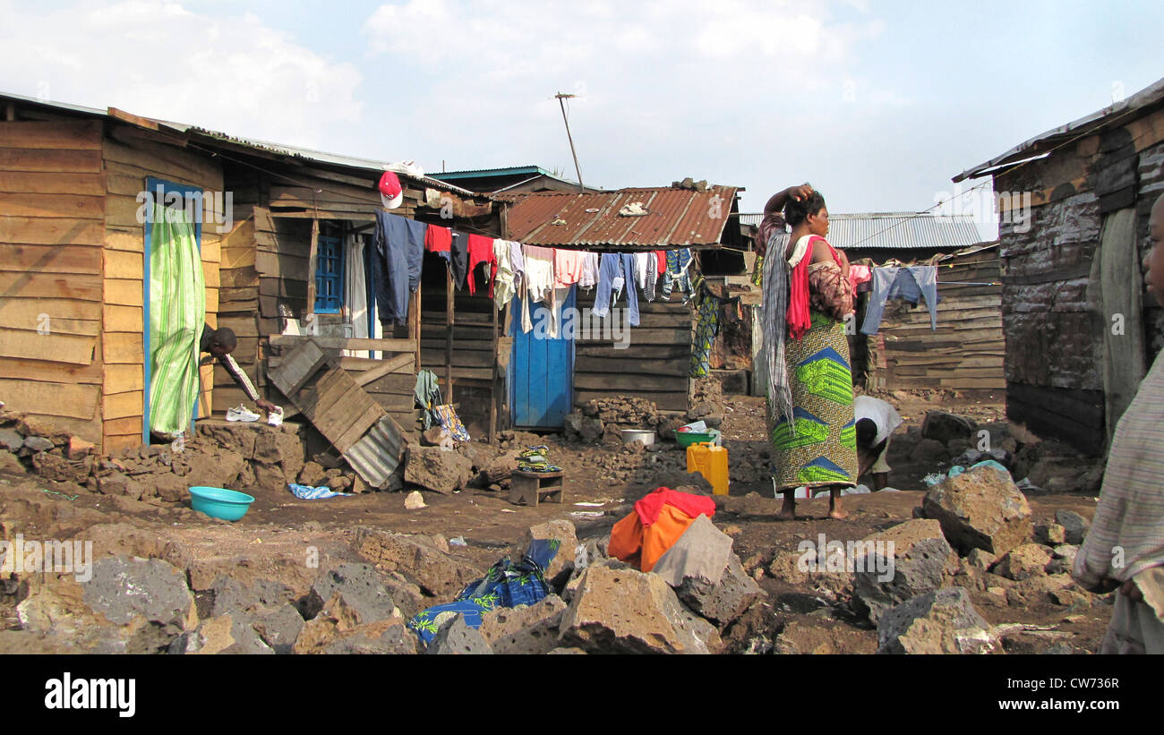 woman hanging up washing in the slums of the city of Goma, being called ...