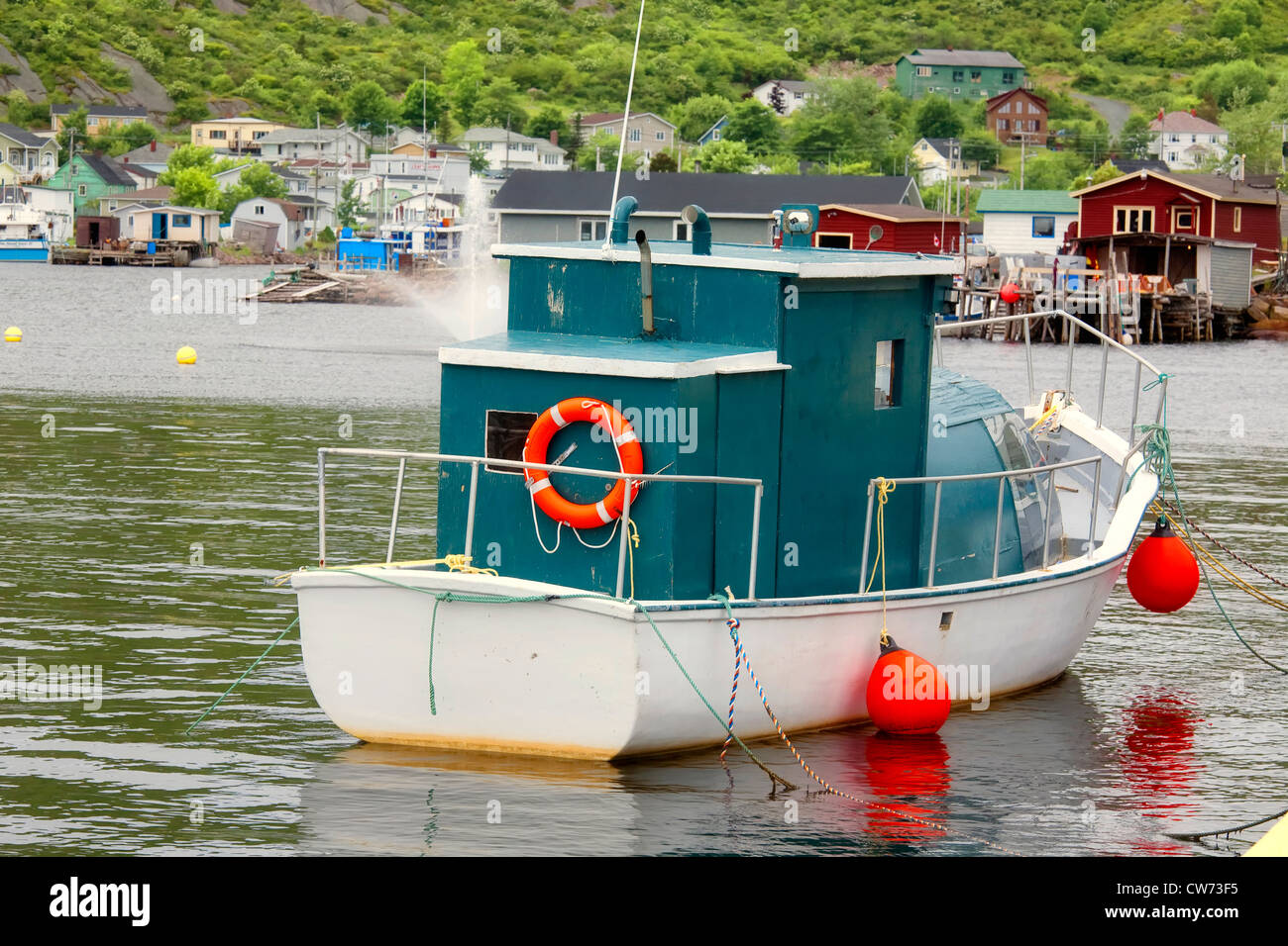 Small fishing or pleasure boat tied up at a wharf in a coastal outport ...