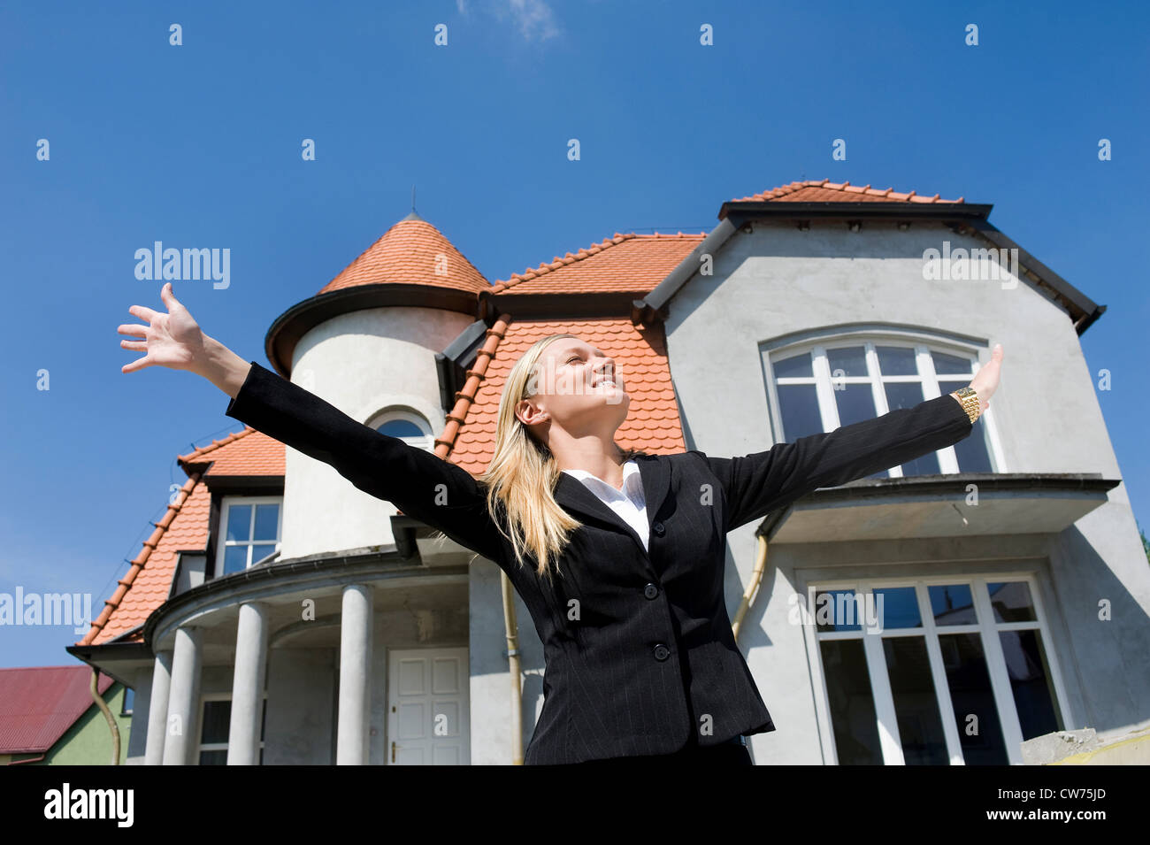 young woman with arms outstretched in front of her house Stock Photo ...