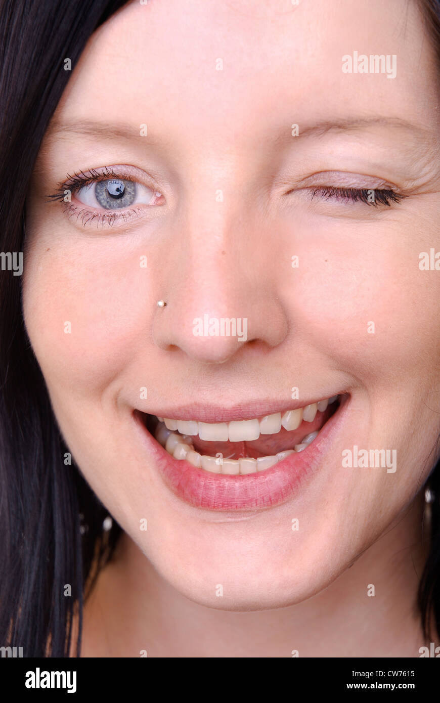 Woman laughs and has one closing eye Stock Photo - Alamy