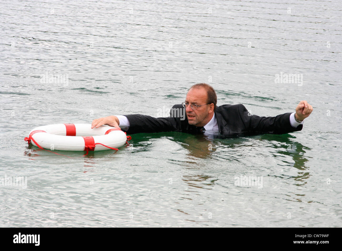 businessman in deep water grabbing to life belt Stock Photo - Alamy
