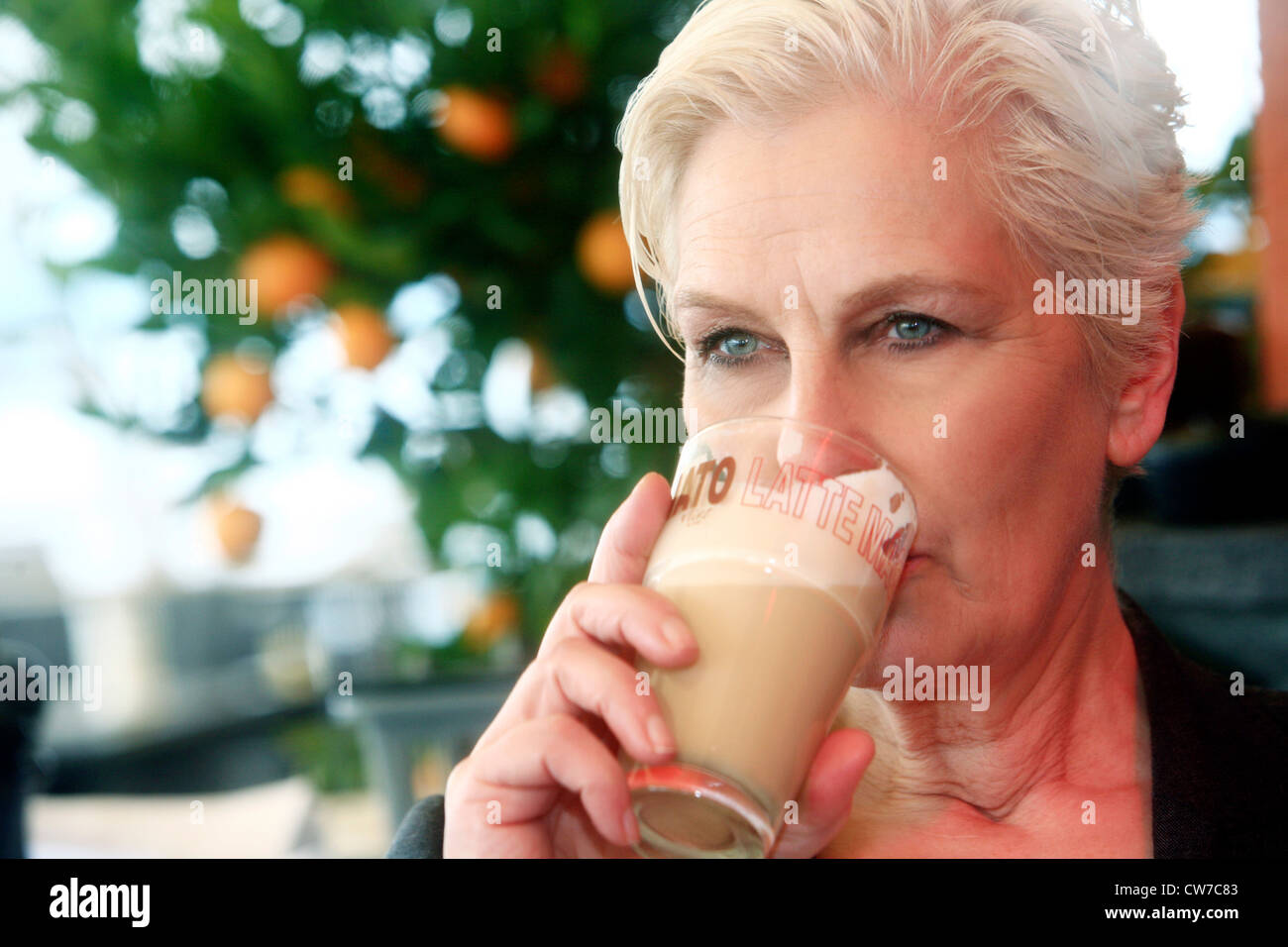 attractive white-haired woman drinking a latte macchiato Stock Photo ...