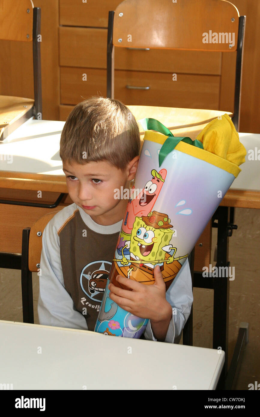 Child holds a paper funnel and sits in the classroom Stock Photo - Alamy