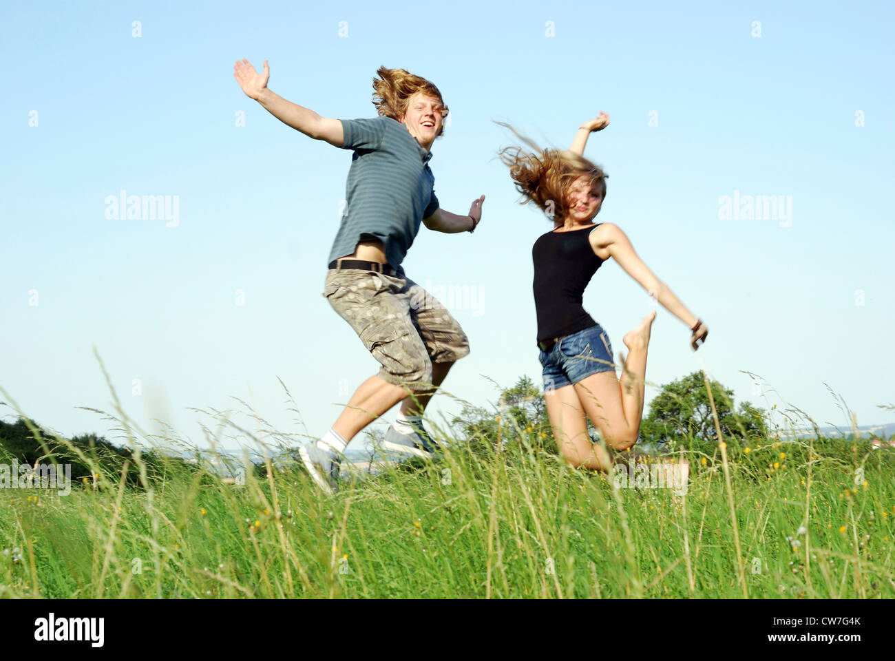 young couple in love cutting a caper on a meadow Stock Photo - Alamy