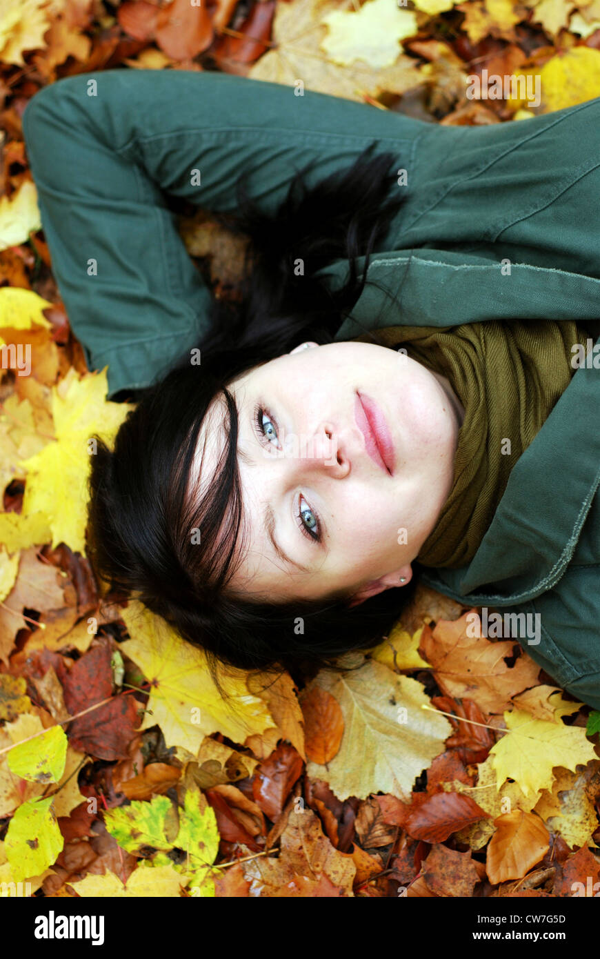 beautiful girl in supine position, lying on autumn foliage Stock Photo ...