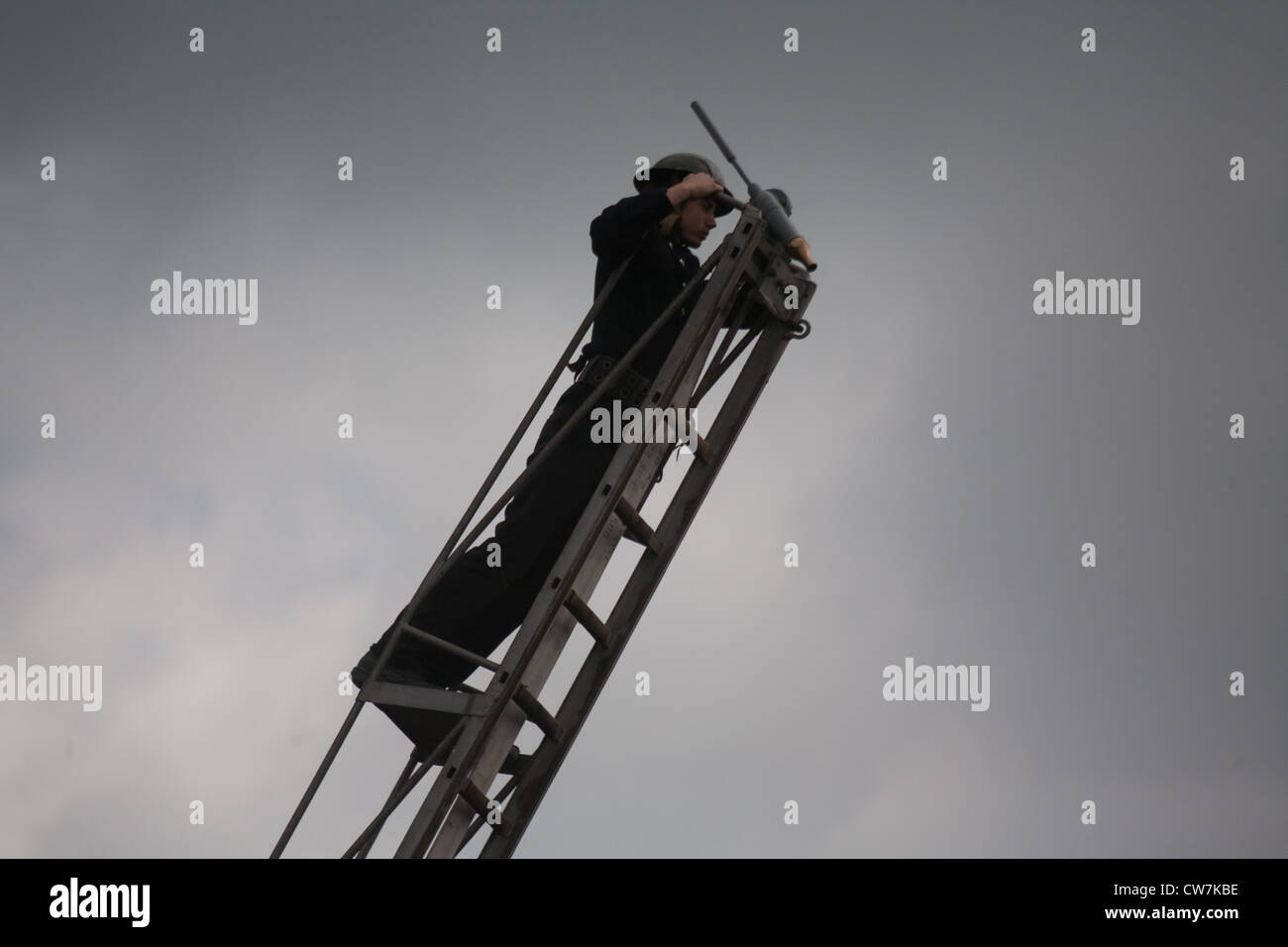 Member of the 1940's National Fire Service on ladder with water jet ...