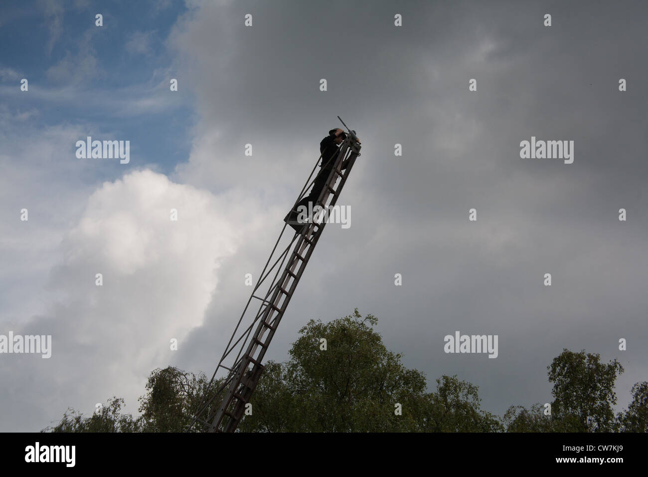 Member of the 1940's National Fire Service on ladder with water jet ...