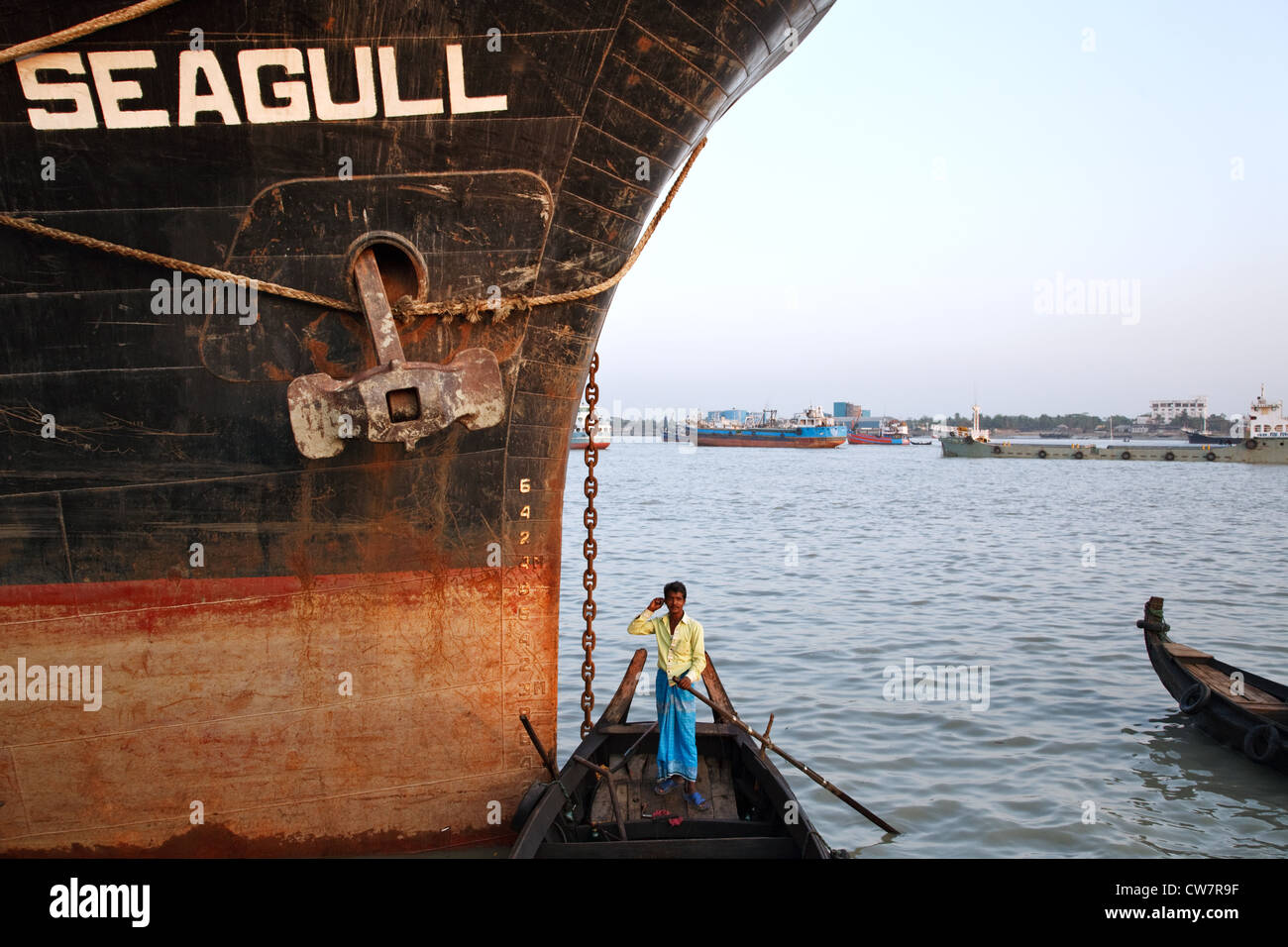 A large ship and boats on Karnaphuli River in Sadarghat port area of ...