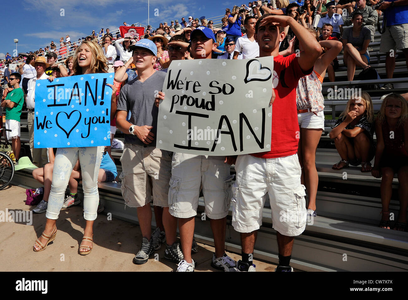 Friends and family of freshman Ian Imamura waves signs during the Class ...