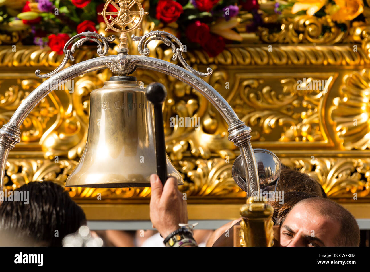 Local worshiper hitting the bell to raise the throne in a religious ...