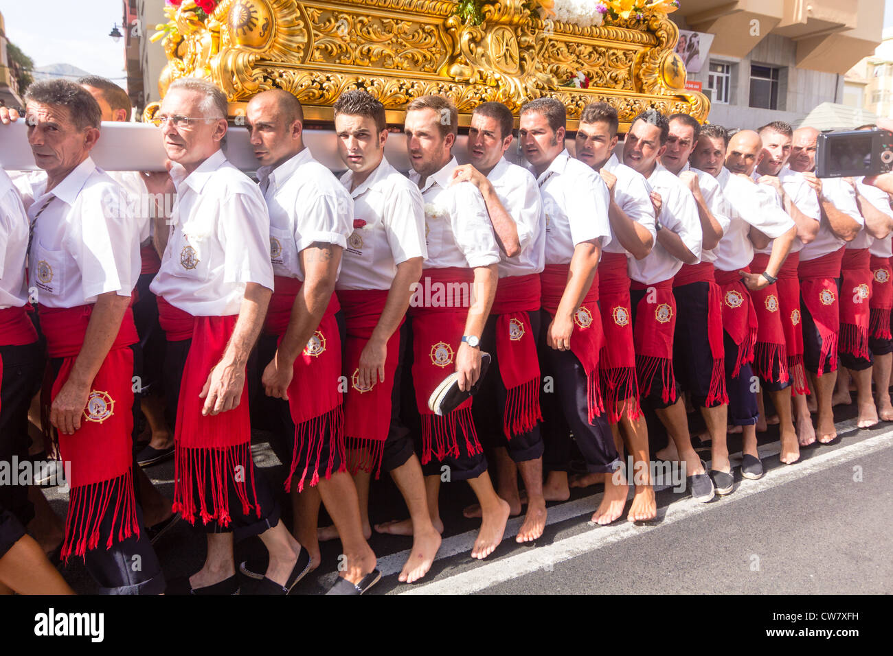 Barefoot worshipers carry a religious image during a procession Stock ...