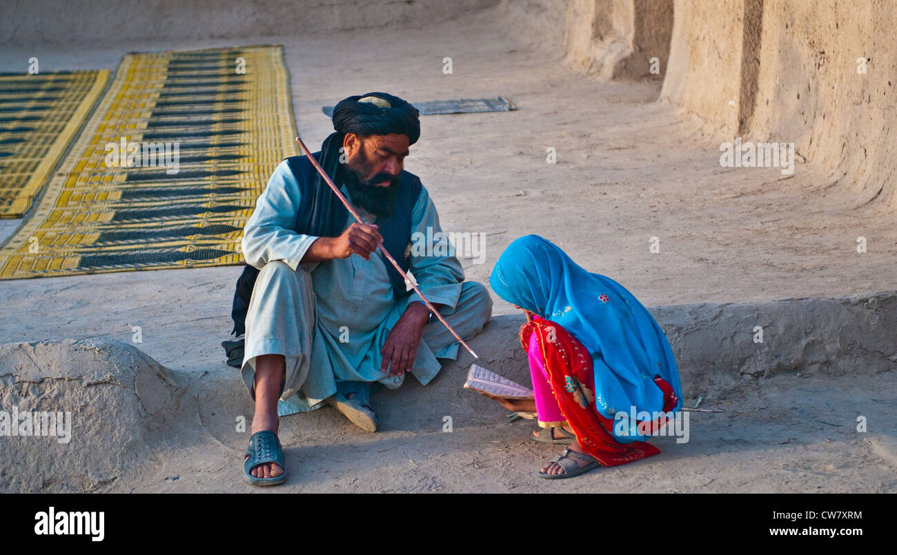 An Afghan villager and young girl read about their religion in the ...