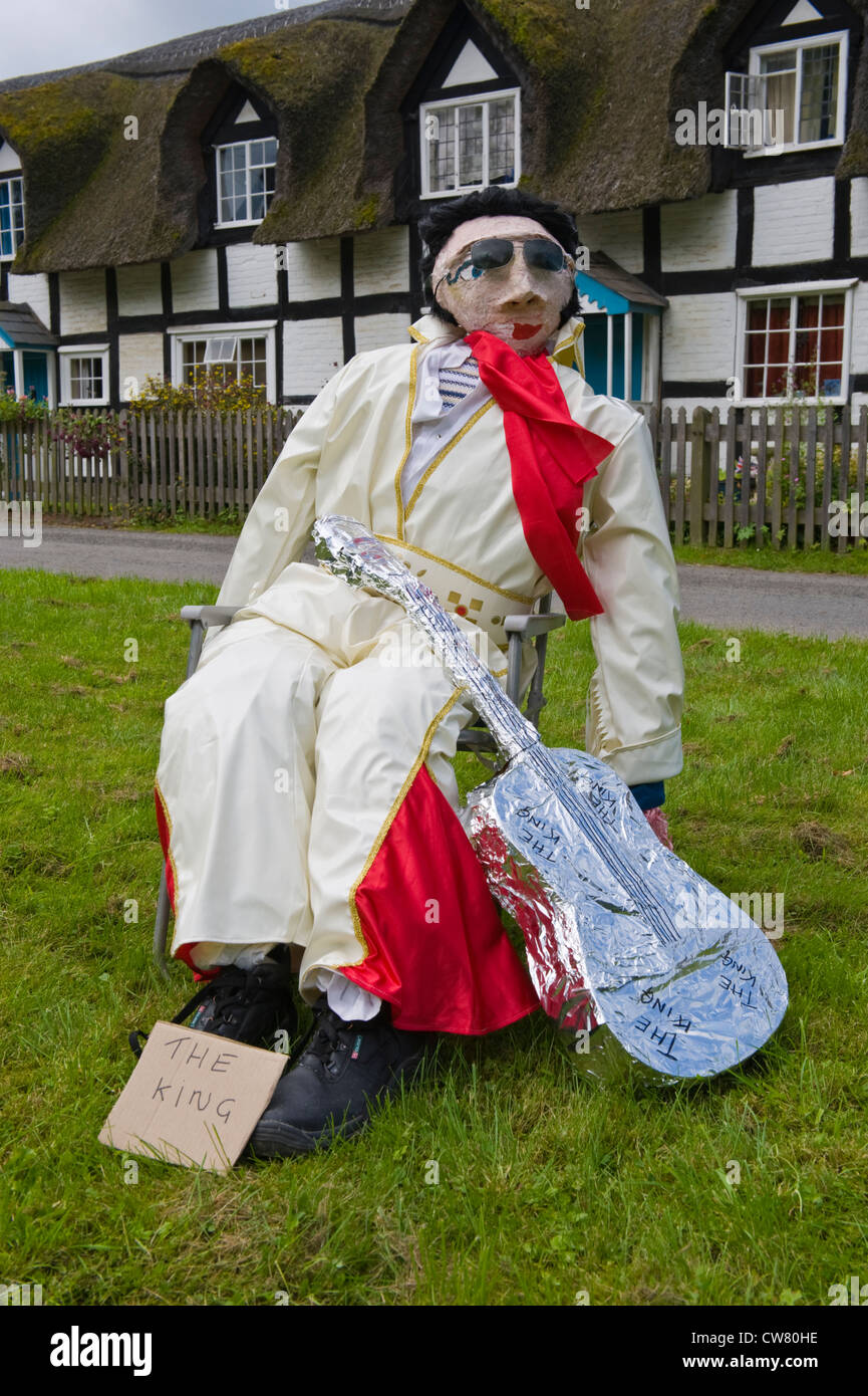 Effigy of Elvis The King outside thatched cottages at village fete on ...