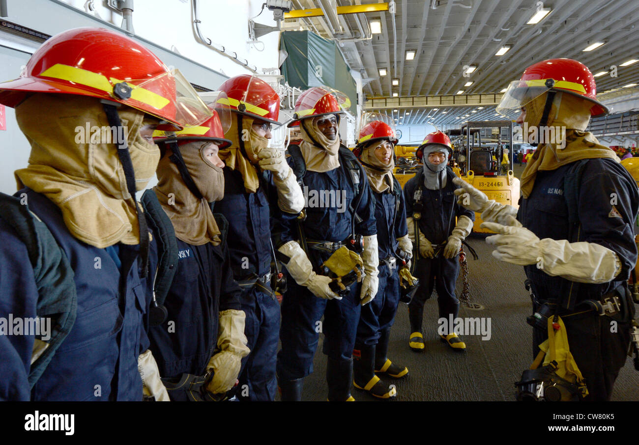 A five-man-hose team prepares for a firefighting simulation during a ...