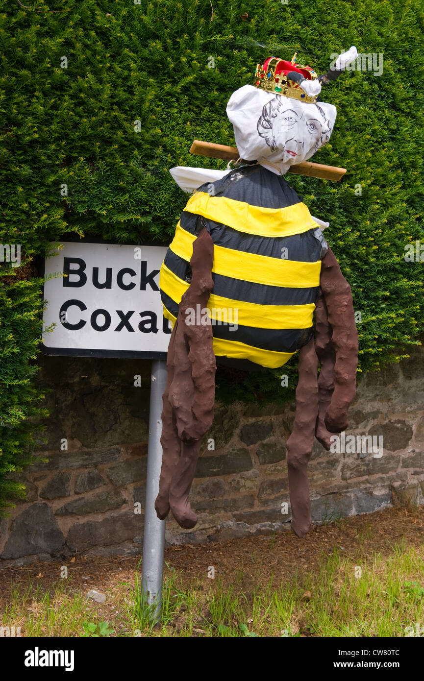 Effigy of Queen Bee perched on road sign at village fete on Scarecrow ...
