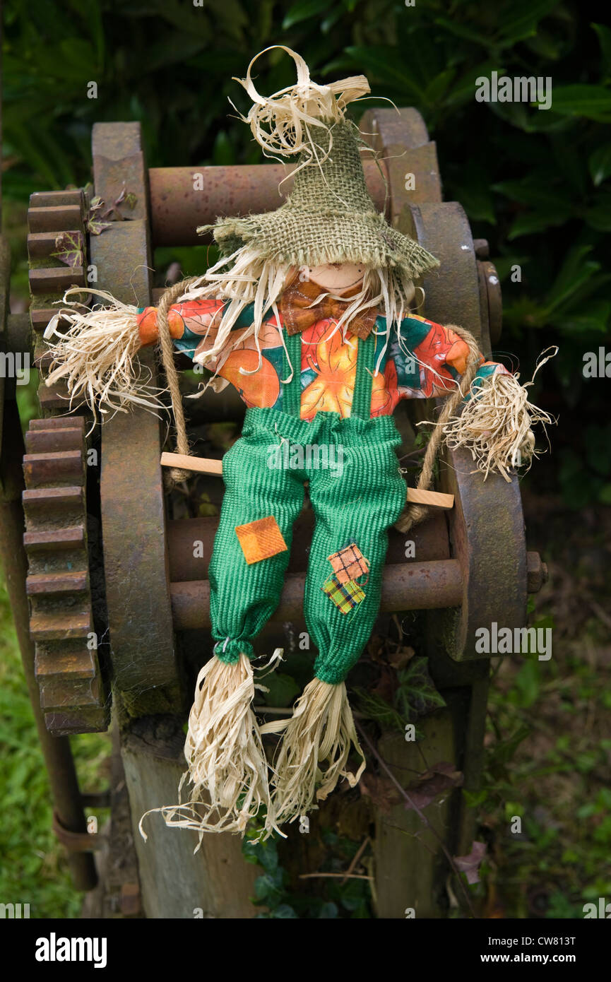 Minature Scarecrow on old machinery in garden at village fete on ...