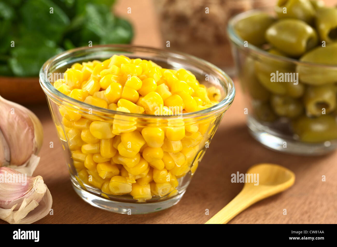 Sweetcorn grains in glass bowl with garlic , green olives, tuna and ...