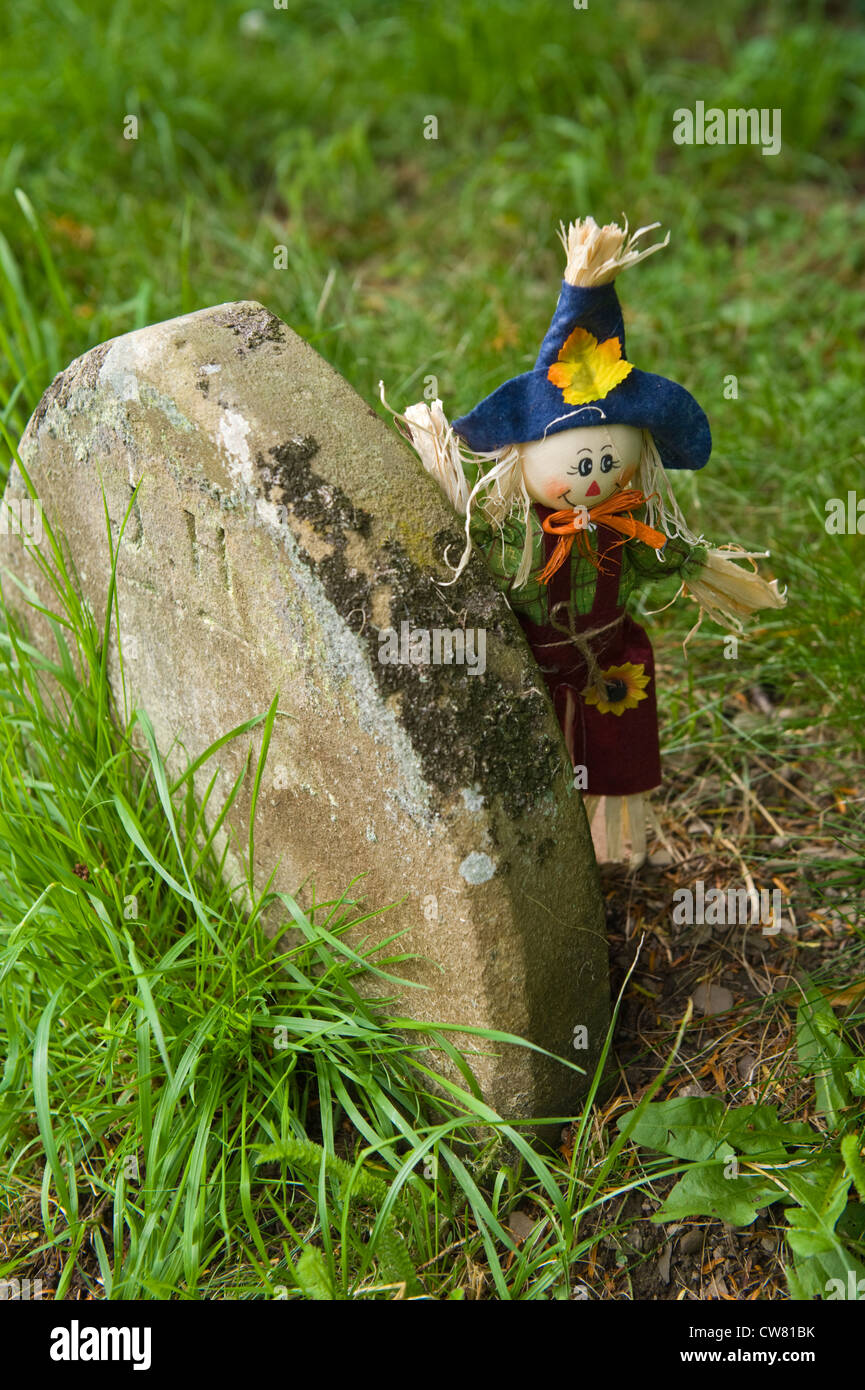 Miniature Scarecrow on gravestone in churchyard at village fete on ...