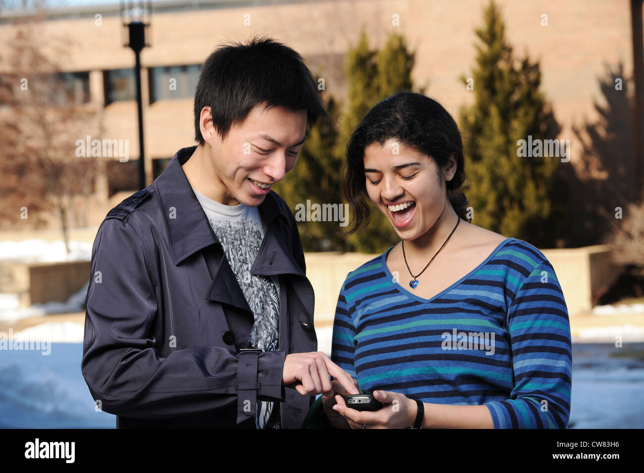 College Students with cell phone in School campus having fun Stock ...