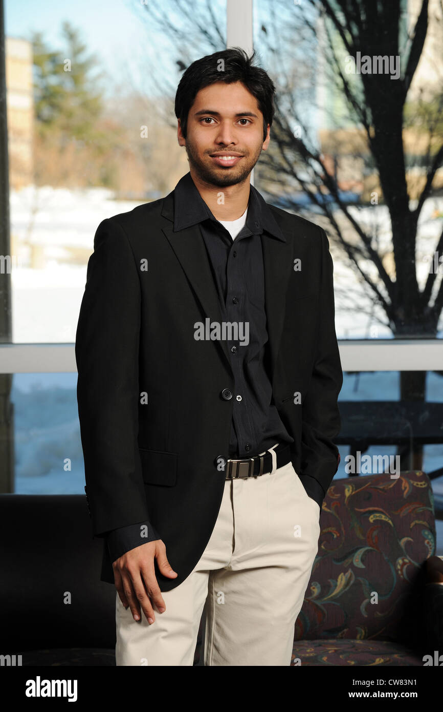 Young Indian Businessman standing up by an office window Stock Photo ...
