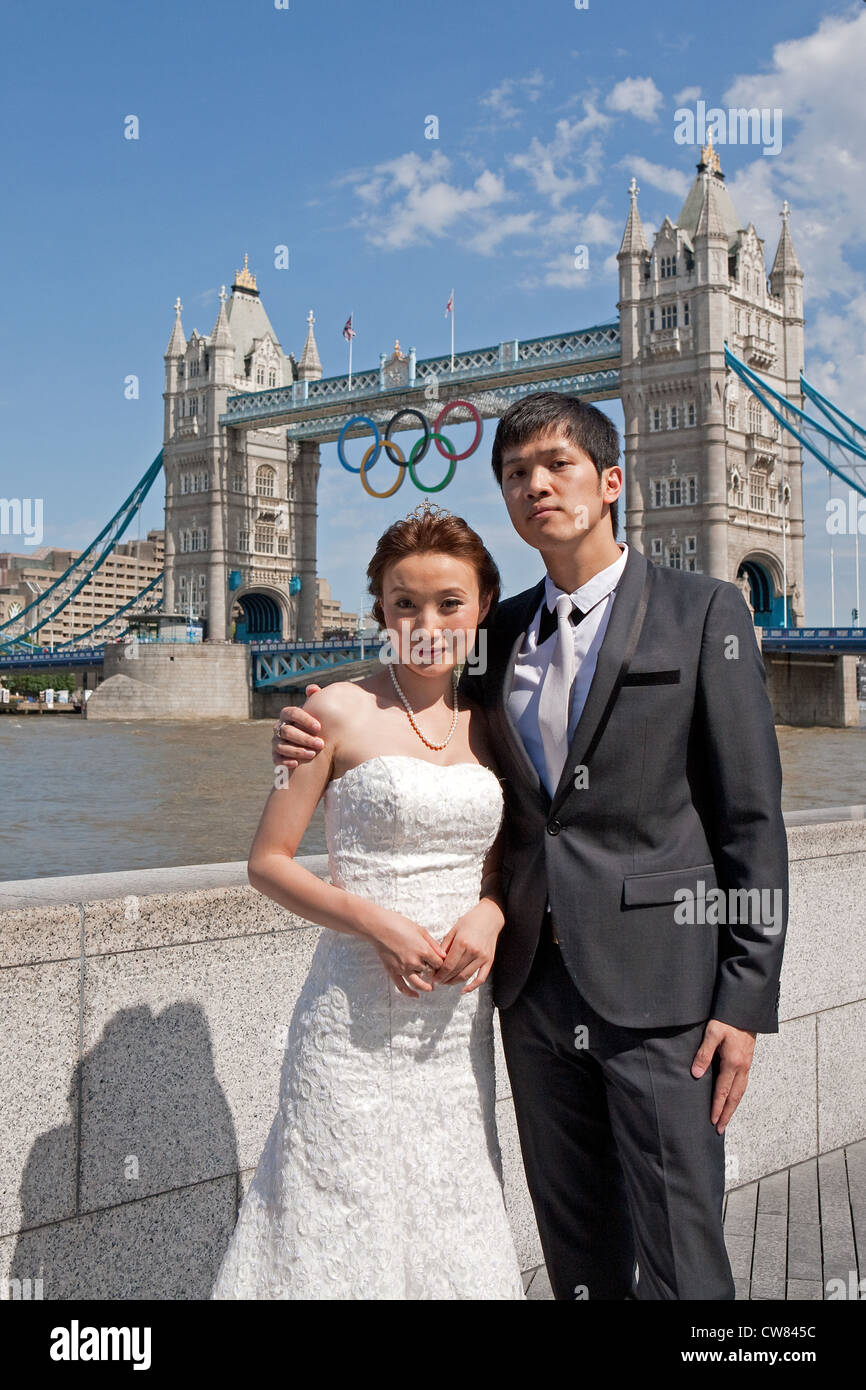 A Bride and Groom standing in front of Tower Bridge by the River Thames ...