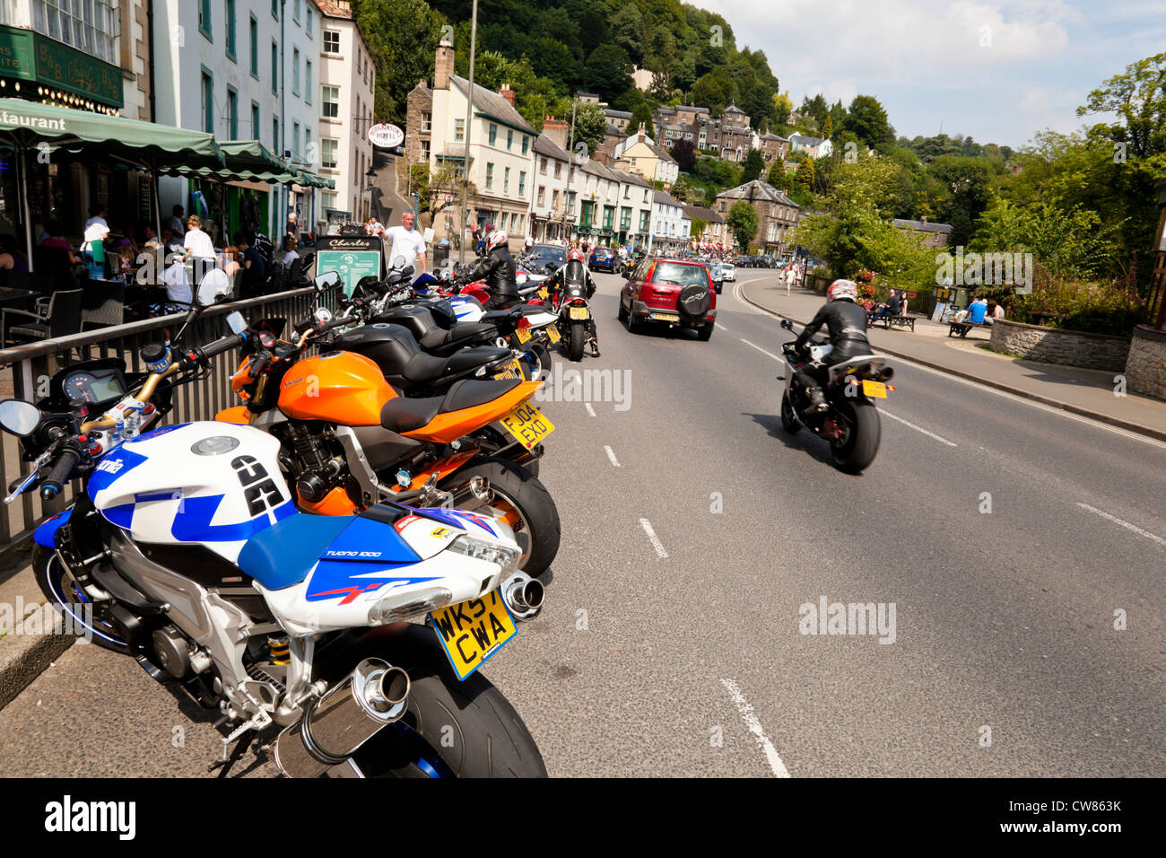 Motorbike rider passing a long line of motorbikes parked on the A6 road ...