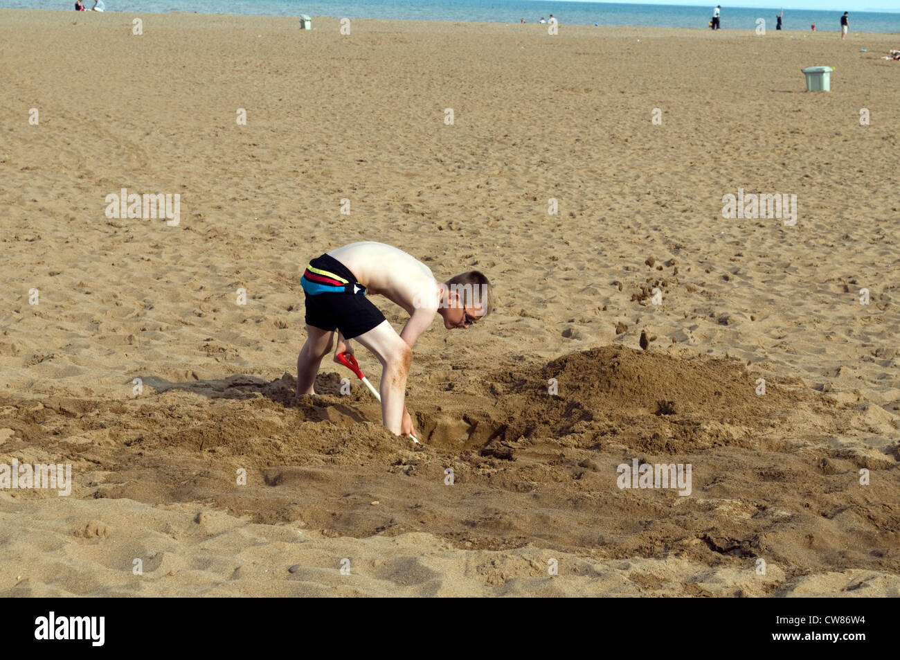 digging hole in the beach Stock Photo - Alamy